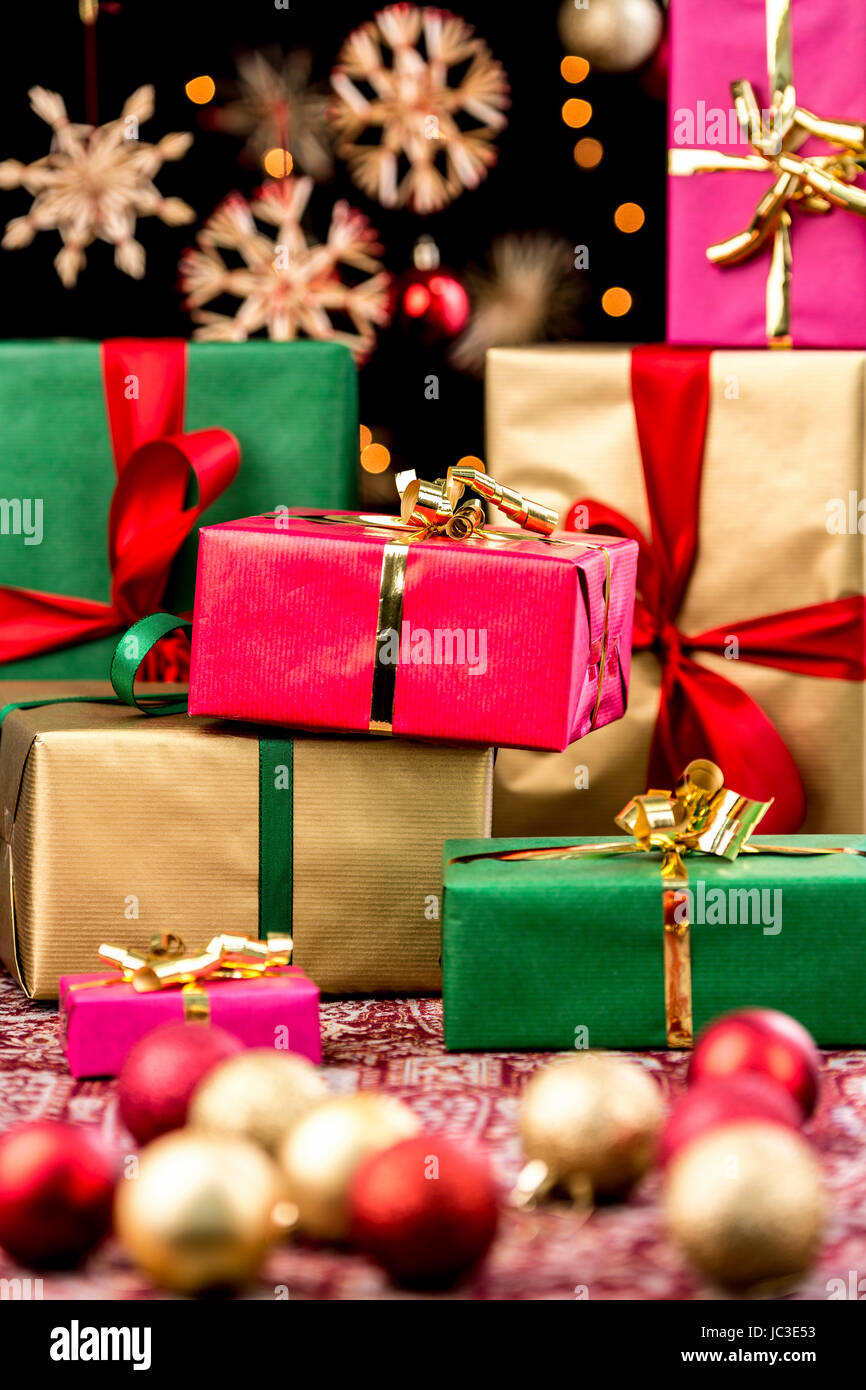 Christmas presents in red, green, gold and magenta. Blurred shapes of ...
