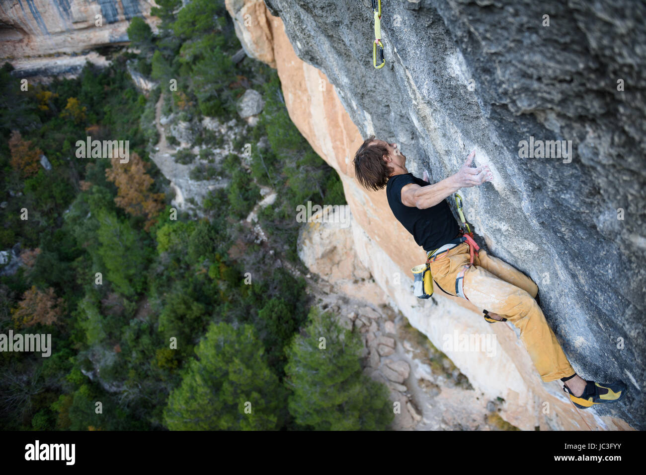Outdoor sport activity. Rock climber ascending a challenging cliff ...