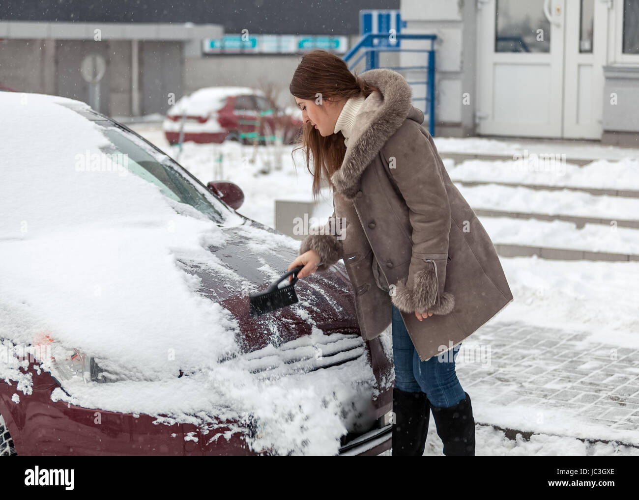 Young woman cleaning her car after snow blizzard Stock Photo - Alamy