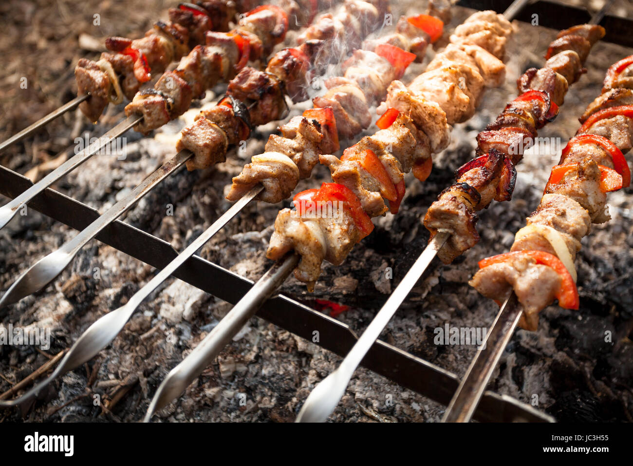 Closeup photo of kebab on metal skewers grilling on fire Stock Photo ...