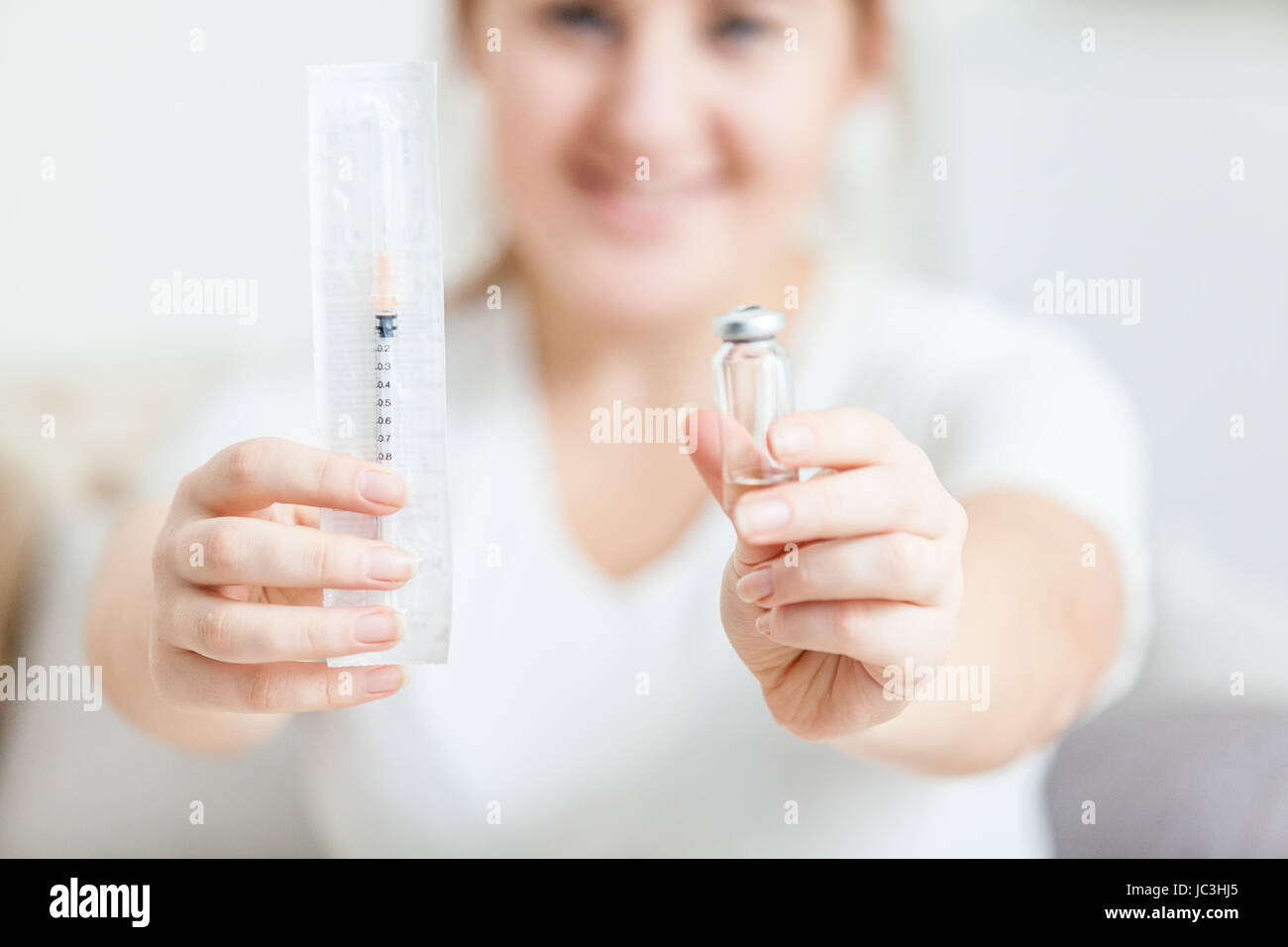 Closeup photo of young woman holding syringe Stock Photo - Alamy