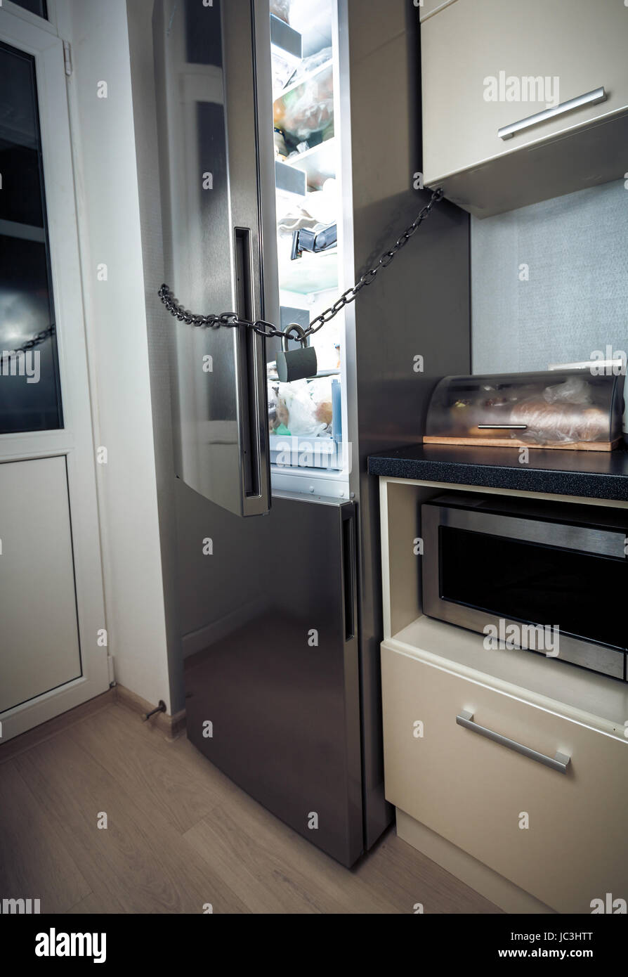 Photo of refrigerator on kitchen locked by chain Stock Photo - Alamy