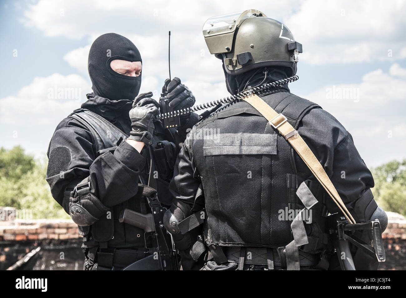 Two spec ops soldiers in black uniform in action Stock Photo - Alamy