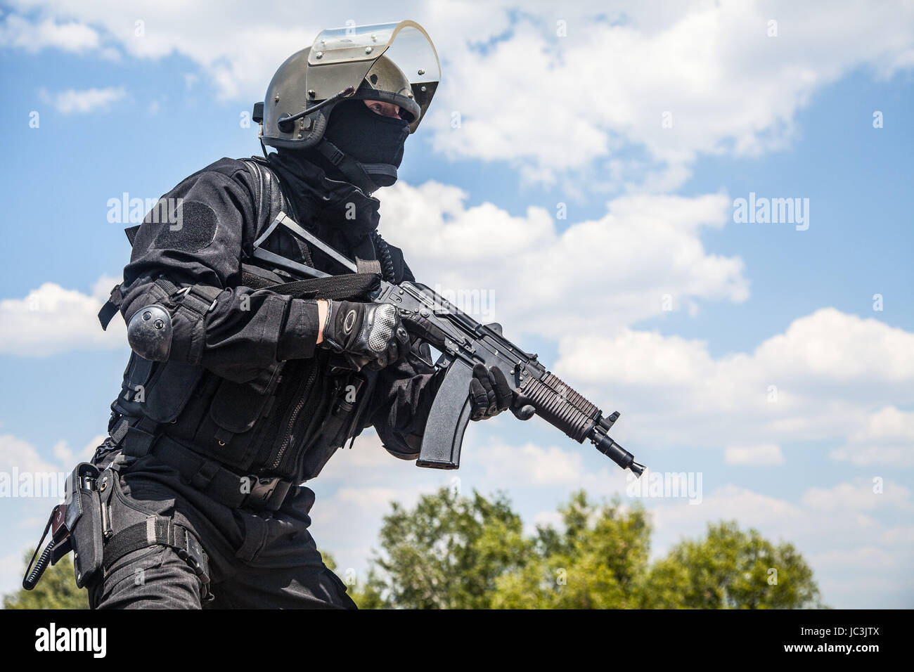 Spec ops soldier in black uniform and face mask with his rifle Stock ...
