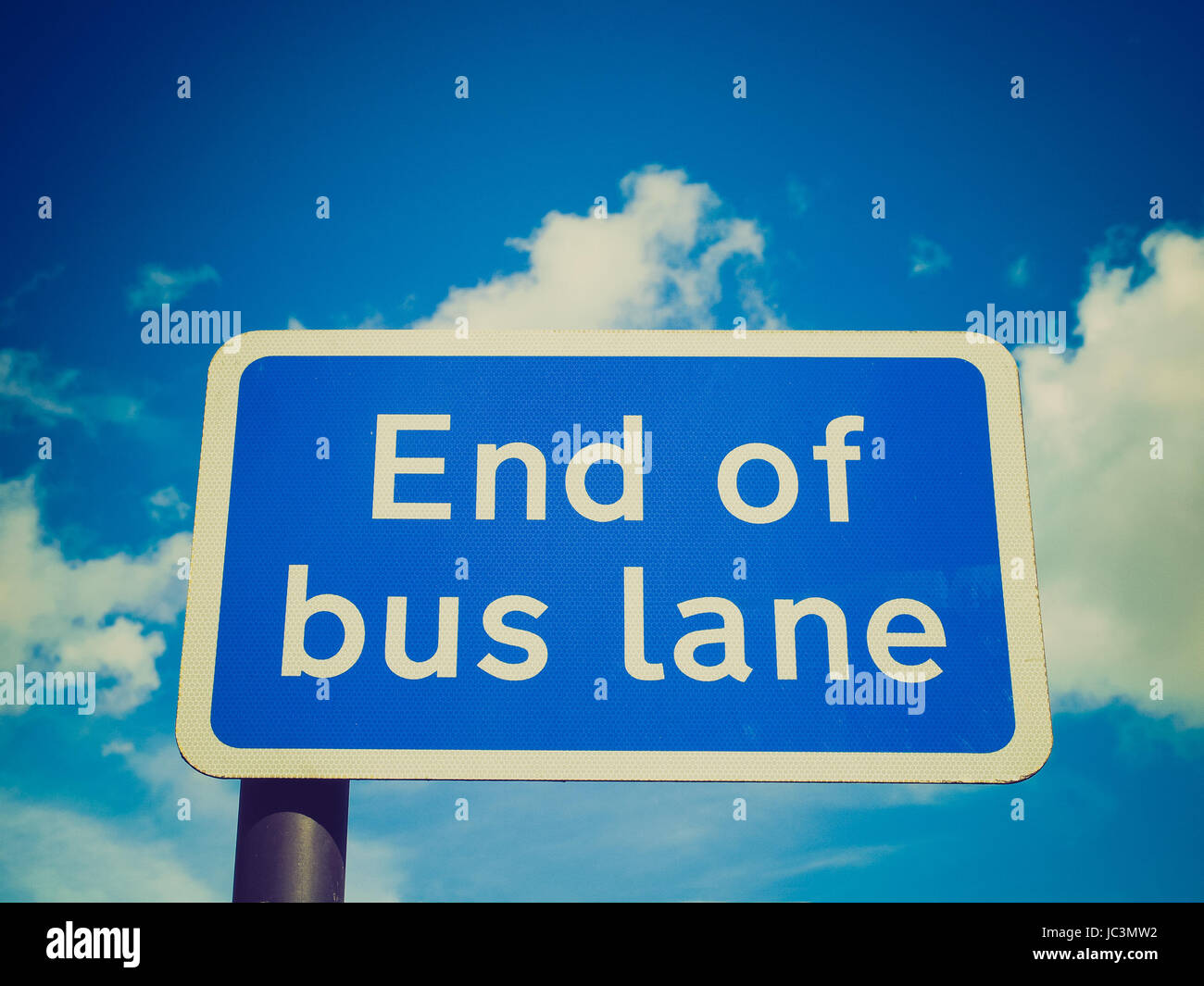 Vintage retro looking End of bus lane sign over blue sky Stock Photo ...