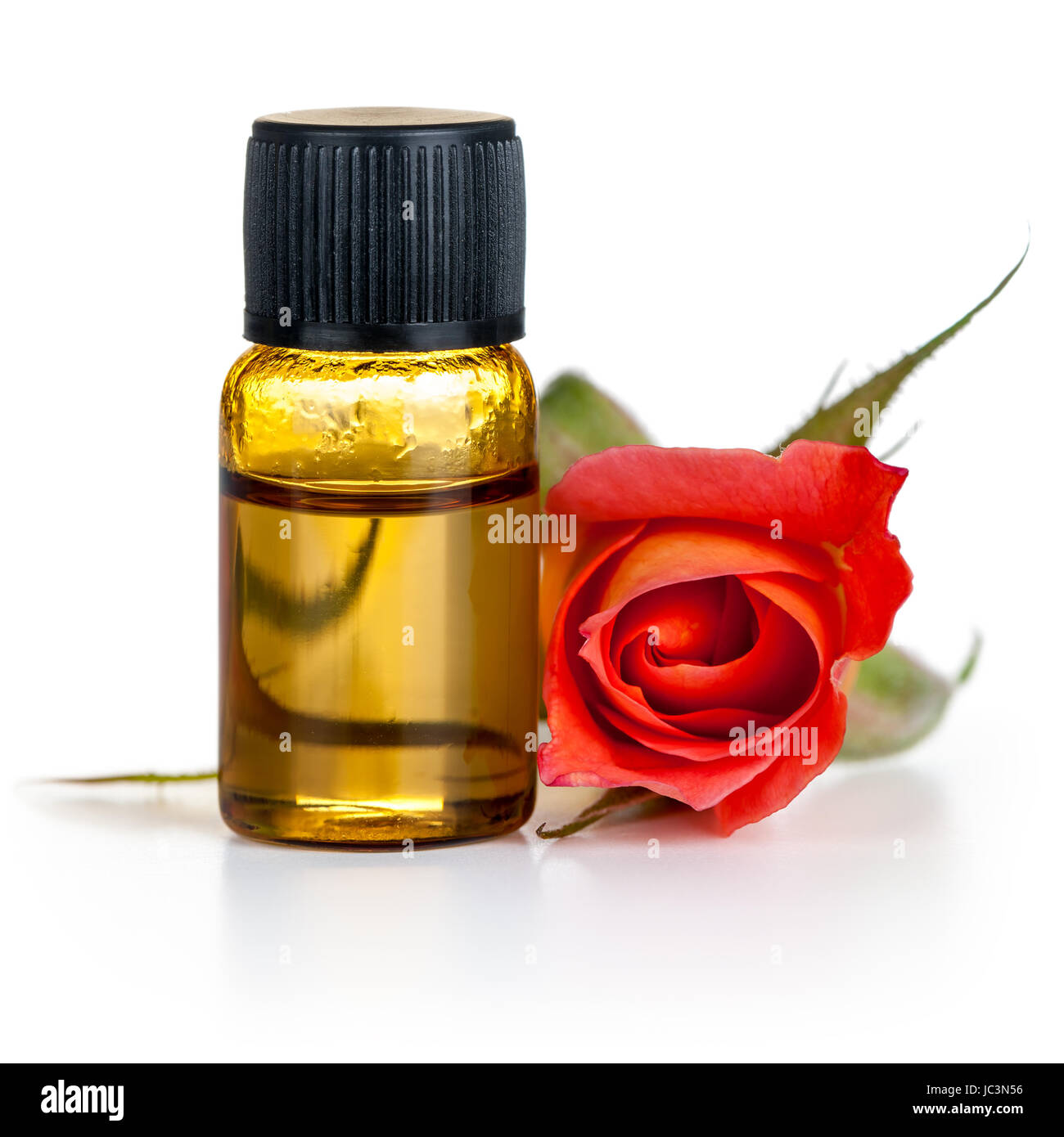Rose oil in bottle with red rose flower on white background Stock Photo ...