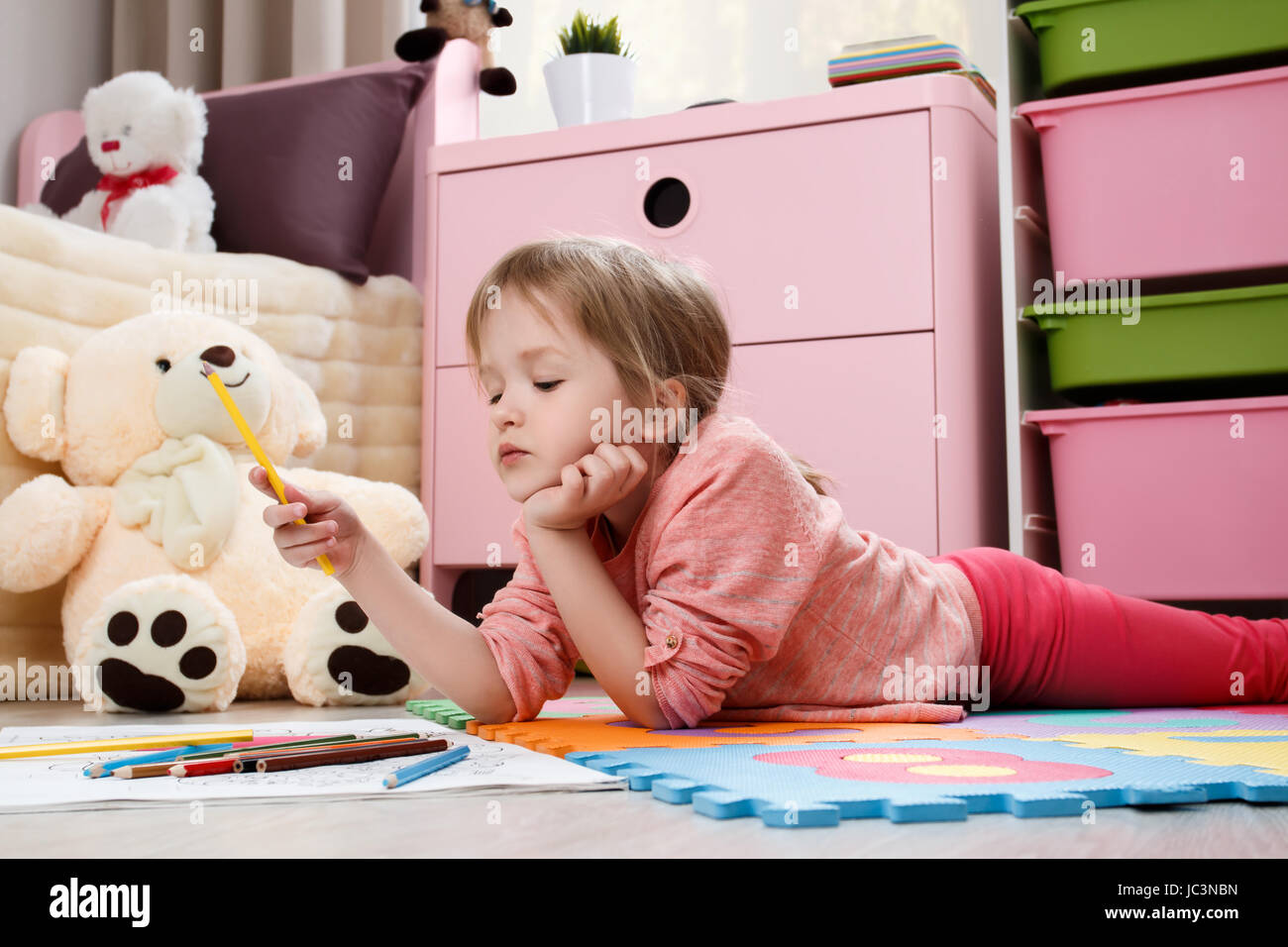 Cute little girl draw with colored pencils in the children's room Stock ...