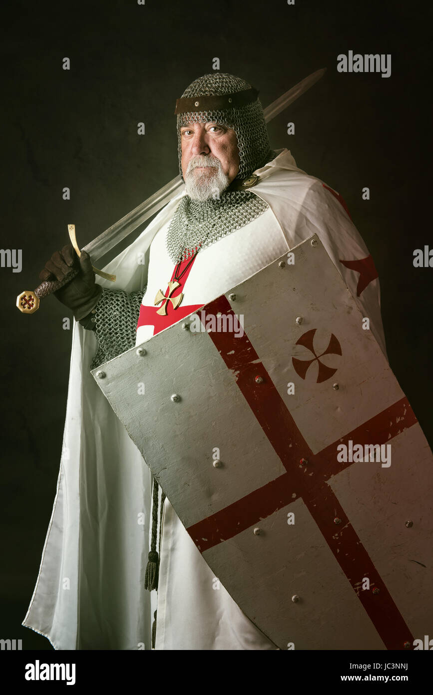 Knight Templar posing with sword in a dark background Stock Photo - Alamy