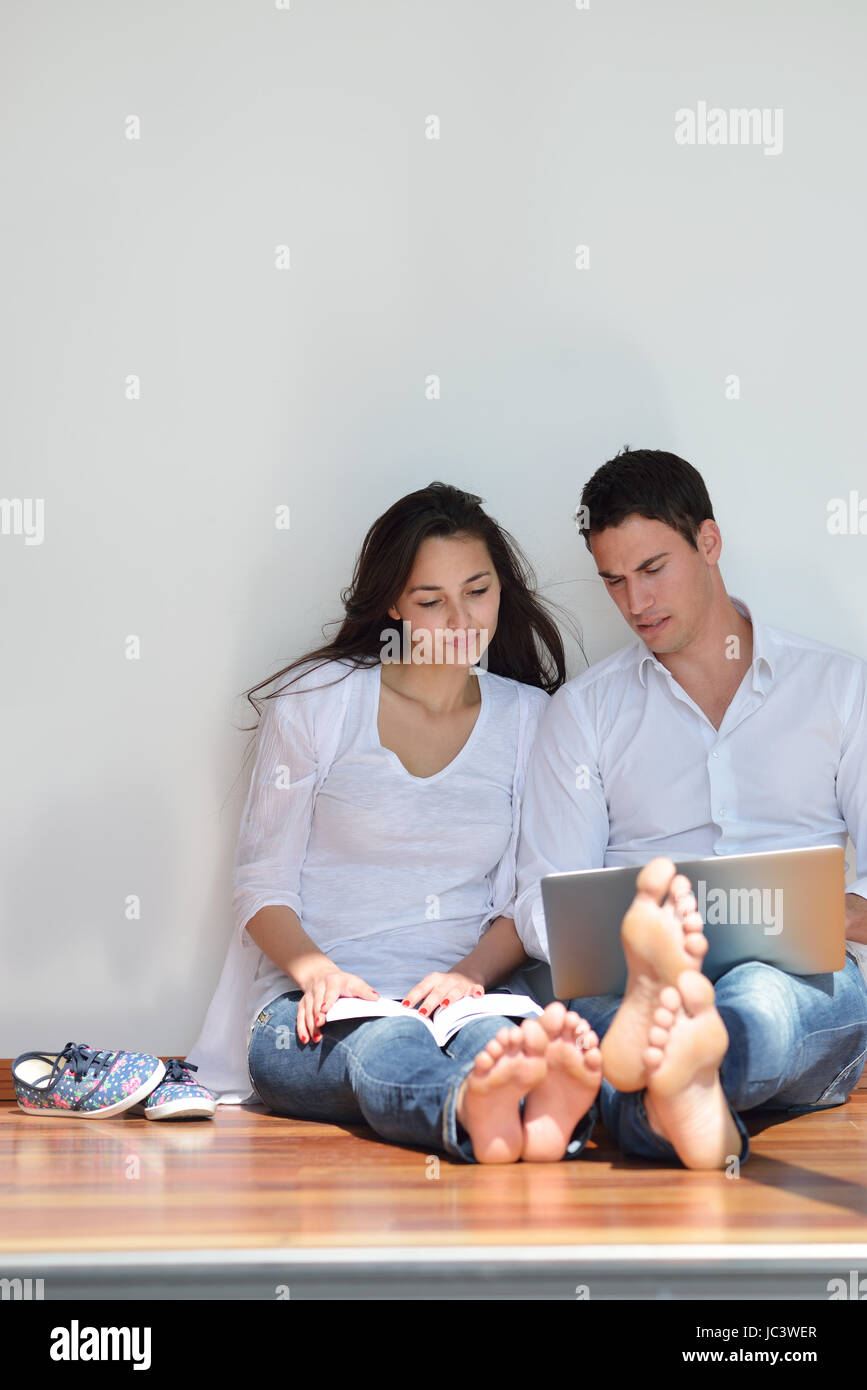 happy young relaxed couple working on laptop computer at modern home ...