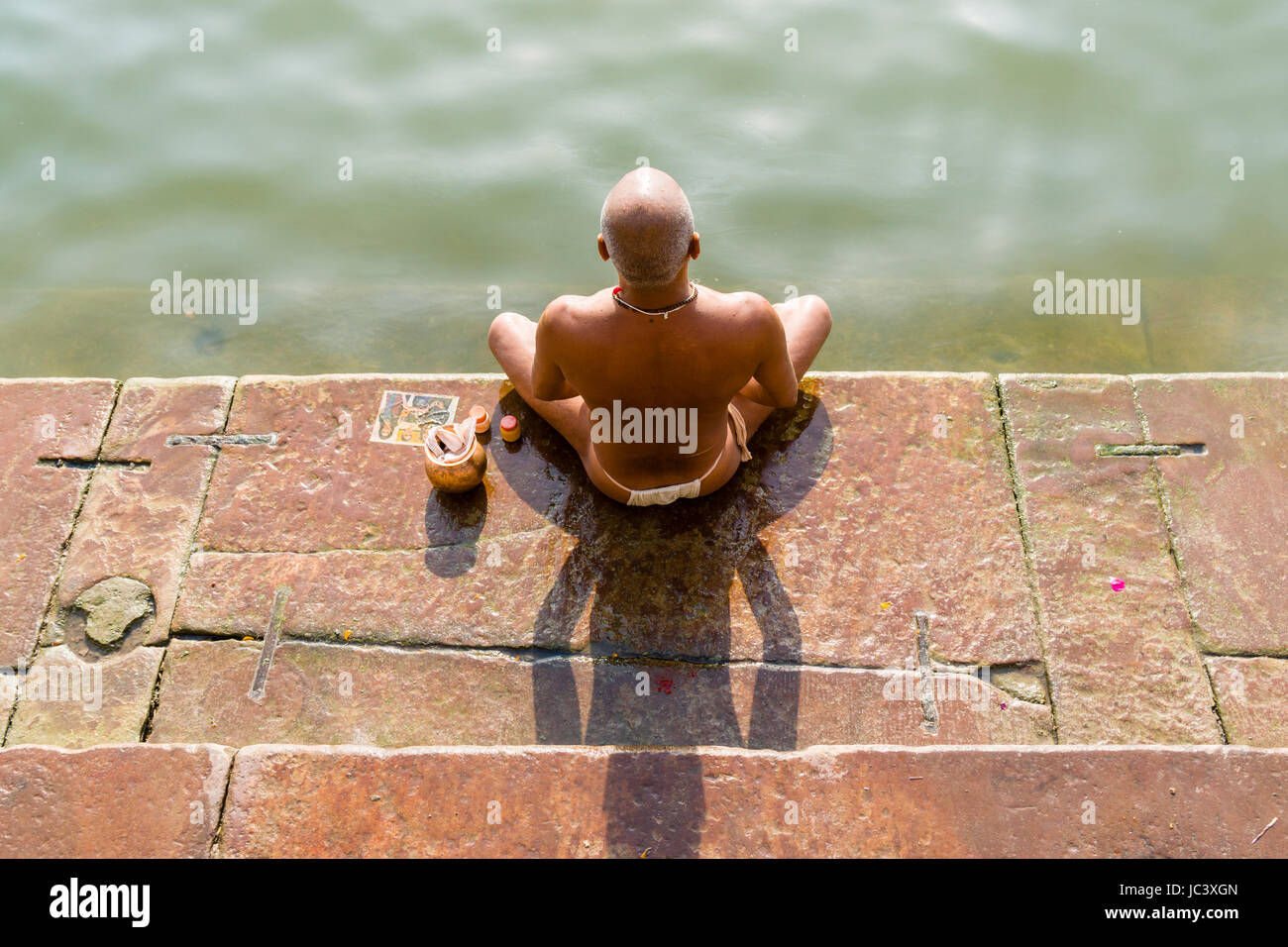 A pilgrim is praying, meditating at the holy river Ganges at ...