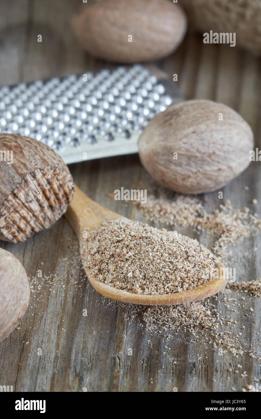 Group of nutmeg seeds with nutmeg powder in wooden spoon Stock Photo ...