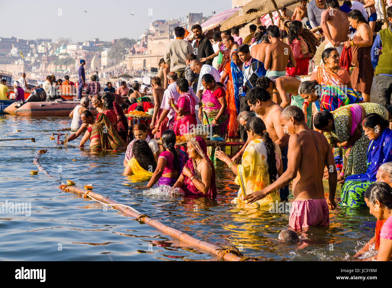 Pilgrims are taking bath in the holy river Ganges at Dashashwamedh Ghat ...