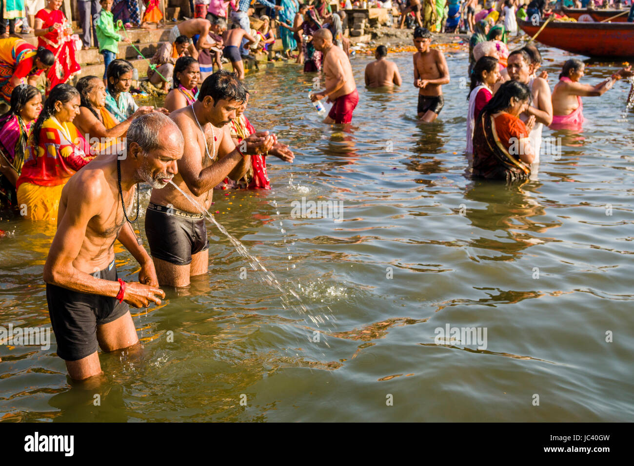 Pilgrims are taking bath in the holy river Ganges at Dashashwamedh Ghat ...