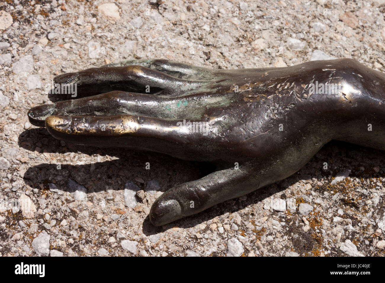 Sculpted bronze woman hand buried in concrete Stock Photo - Alamy