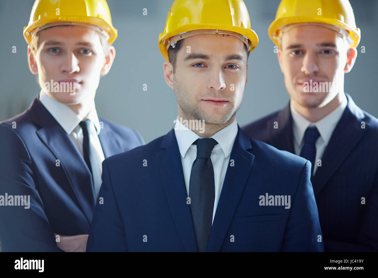Portrait of three serious businessmen in hardhats Stock Photo - Alamy
