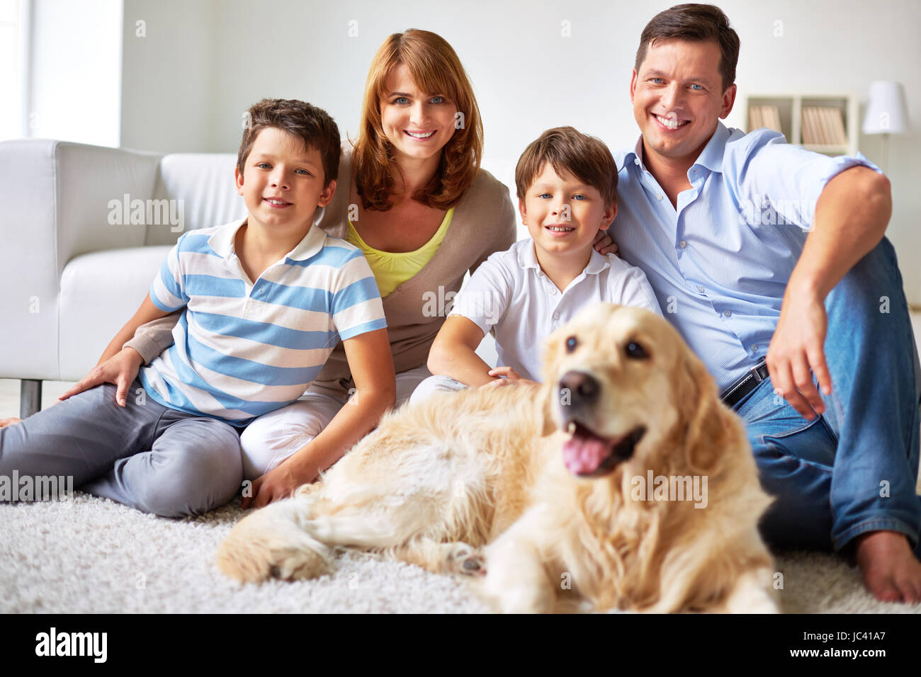 Happy family of four with a dog Stock Photo - Alamy