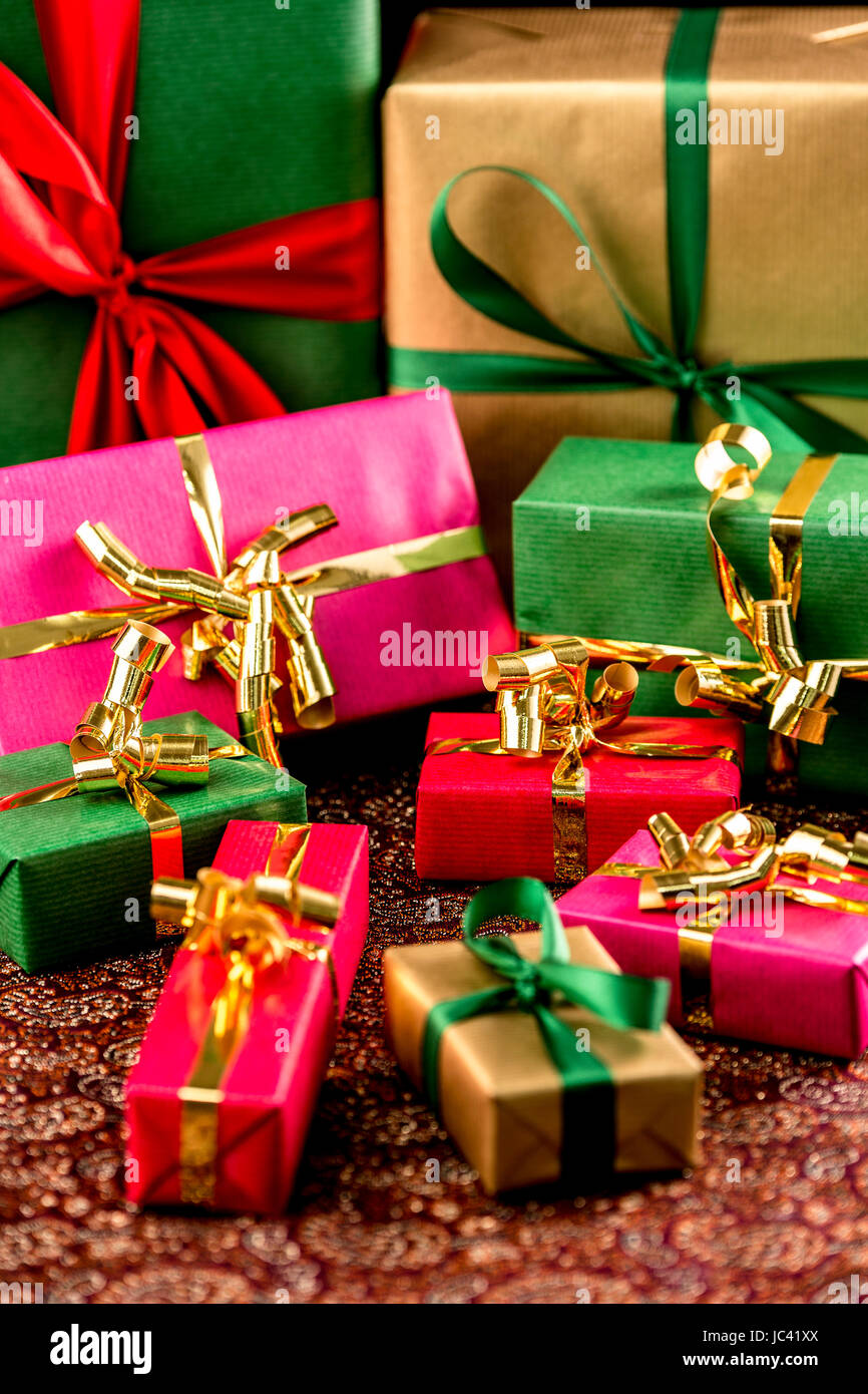 Nine gifts wrapped in green, gold, red and magenta. Narrow depth of ...