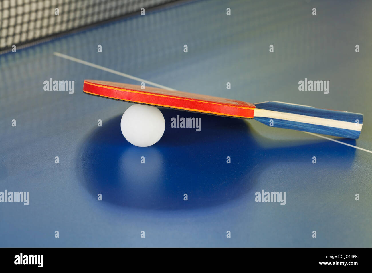 racket, tennis ball on blue ping pong table close up Stock Photo - Alamy