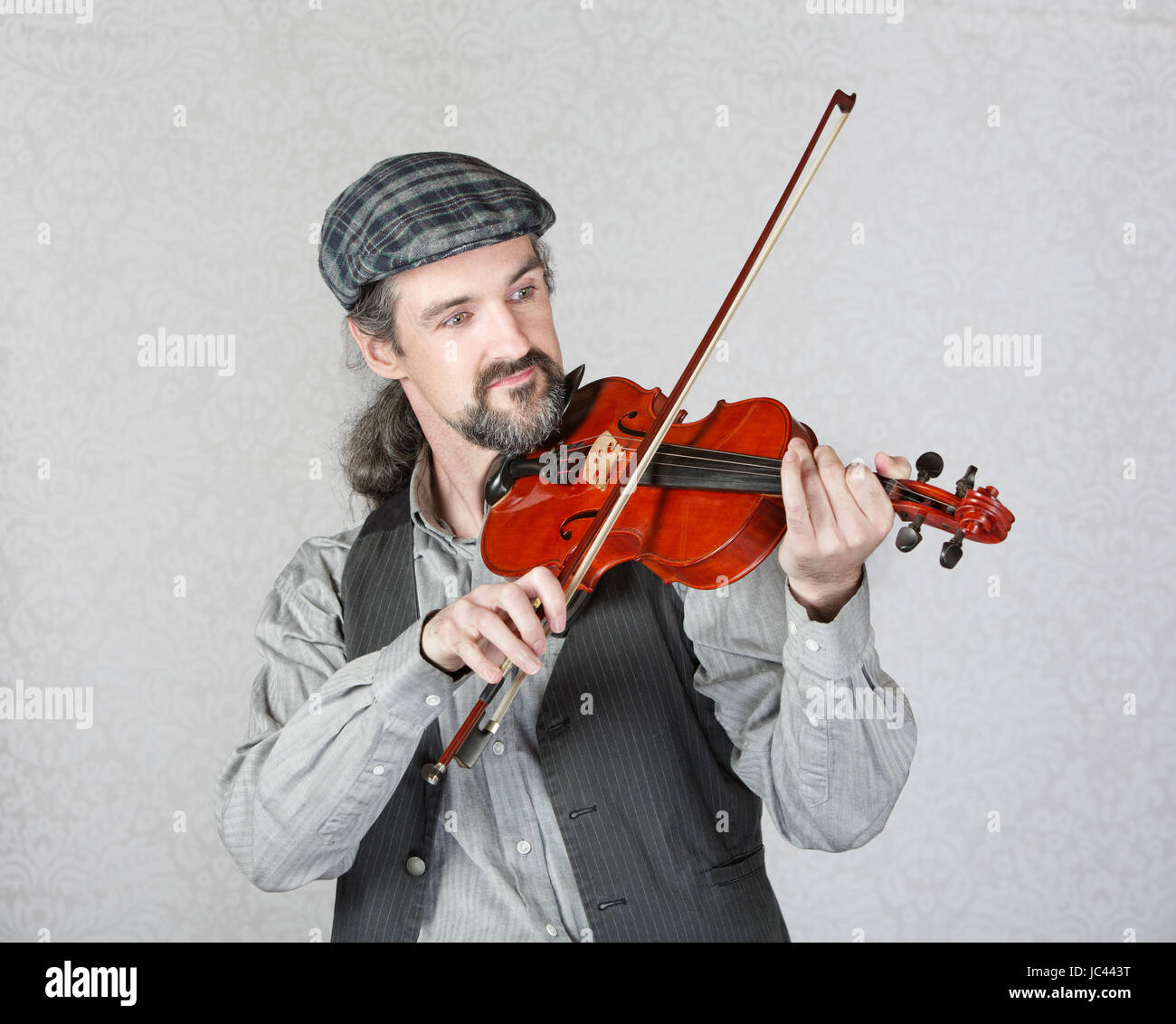 Single handsome Irish fiddler with beard playing music Stock Photo - Alamy