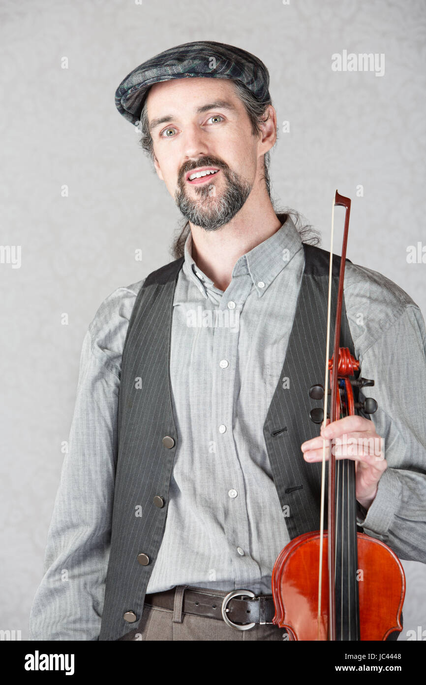 One cheerful Irish fiddler with violin and bow Stock Photo - Alamy