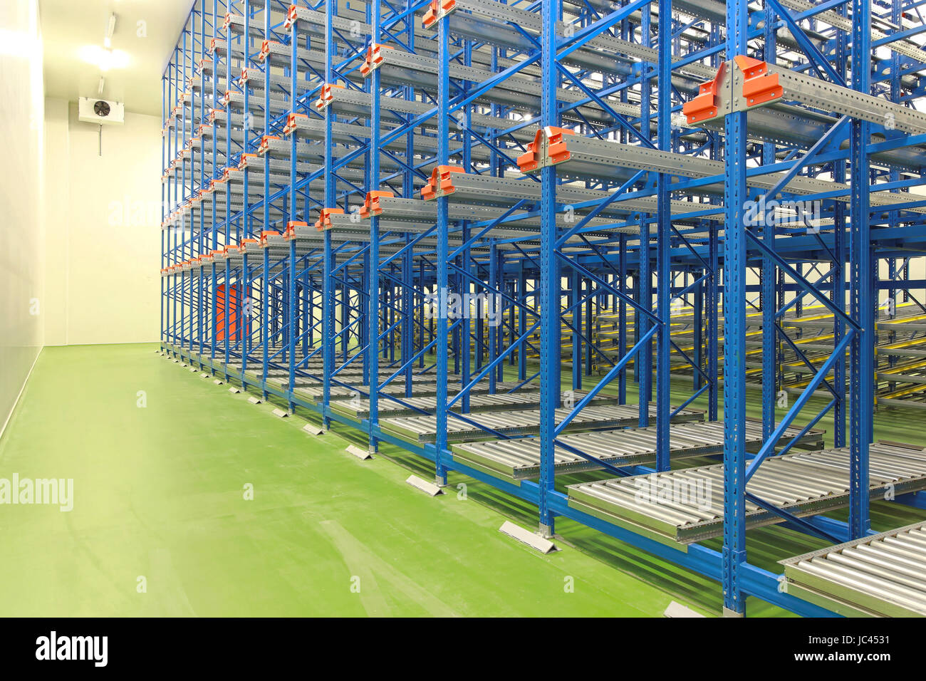 Dynamic storage with conveyer rollers in new warehouse Stock Photo - Alamy