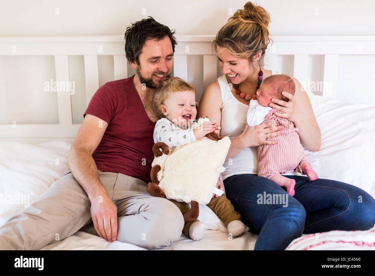 Young parents in bed with their cute little children Stock Photo - Alamy