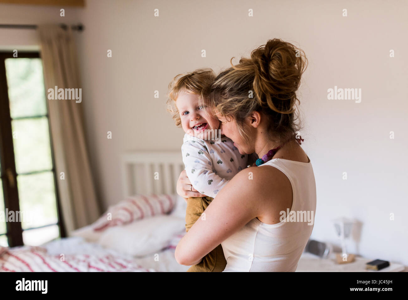 Young mother at home holding her cute little son Stock Photo - Alamy