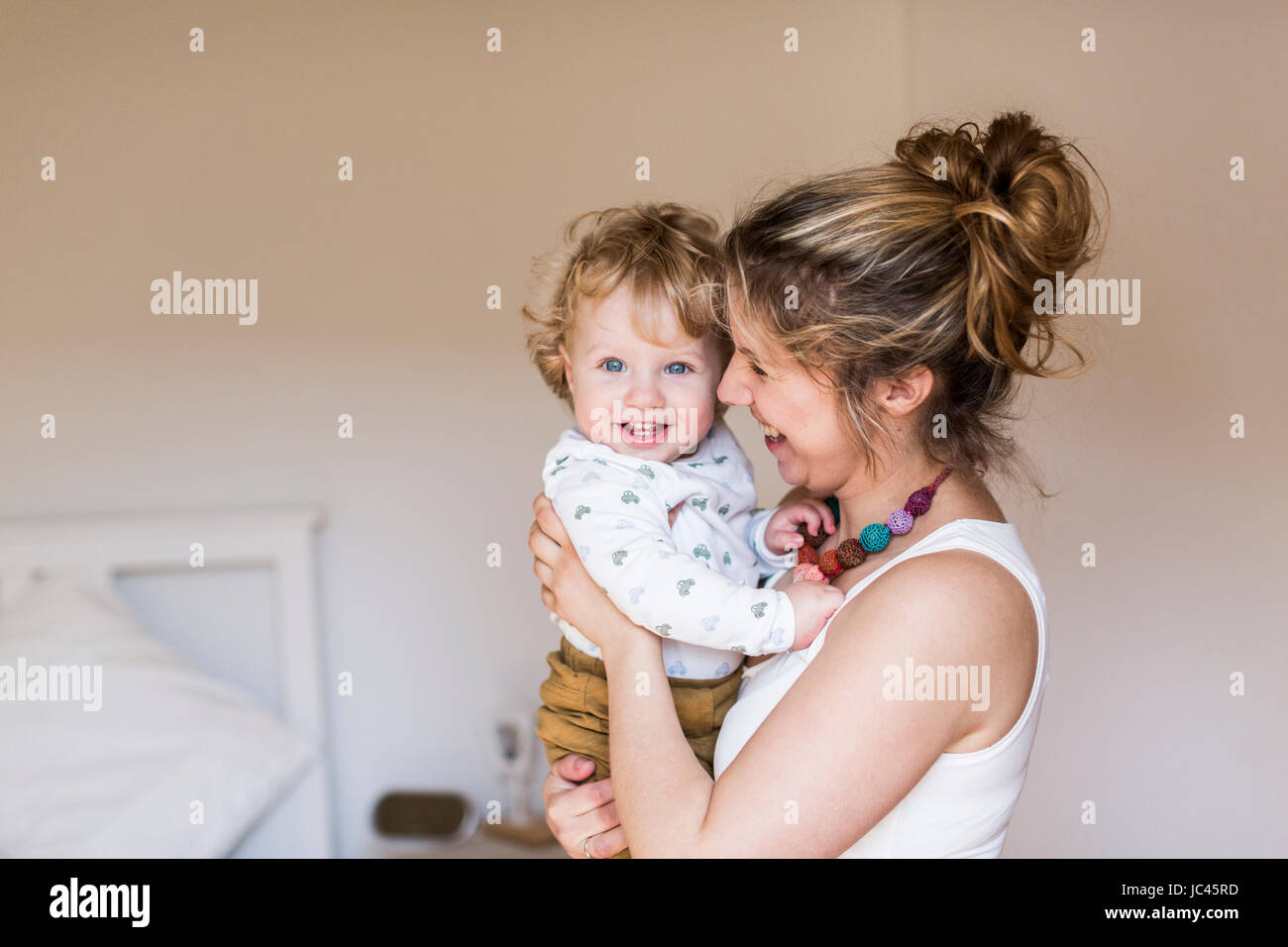 Young mother at home holding her cute little son Stock Photo - Alamy