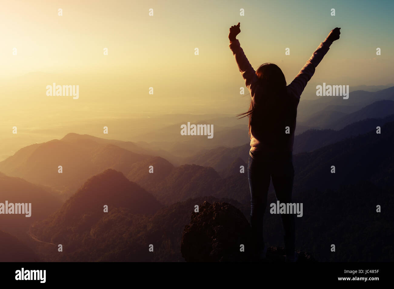 Silhouette woman rising hands hi-res stock photography and images - Alamy