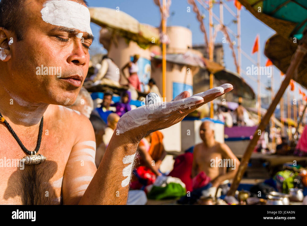 A priest, Brahmin, is performing a religious ritual at Dashashwamedh ...