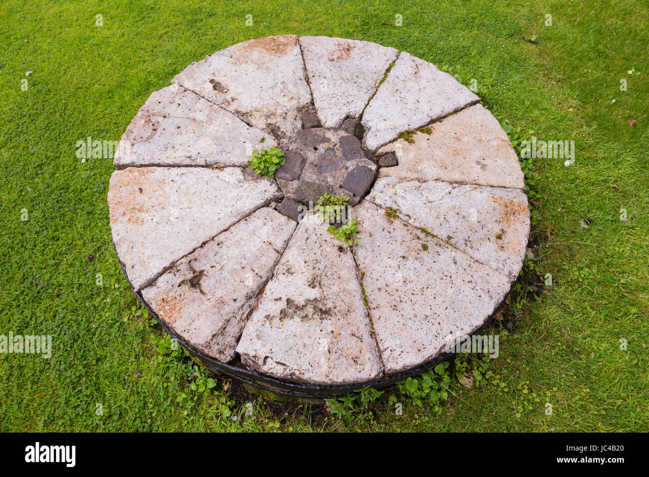 Old millstone placed as a garden feature in a lawn Stock Photo - Alamy