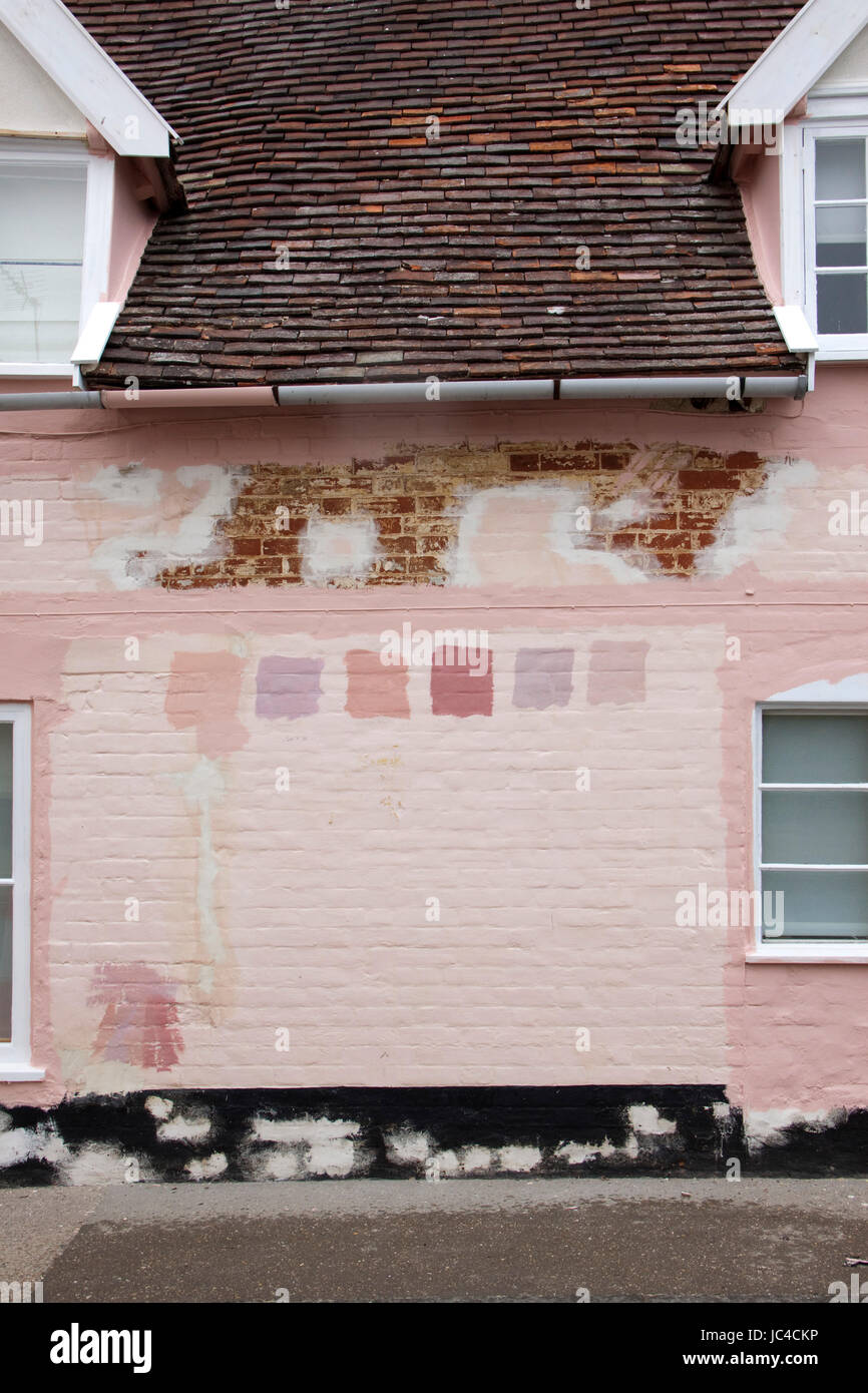 Pink Suffolk house wall prepared for painting with colour/color test ...