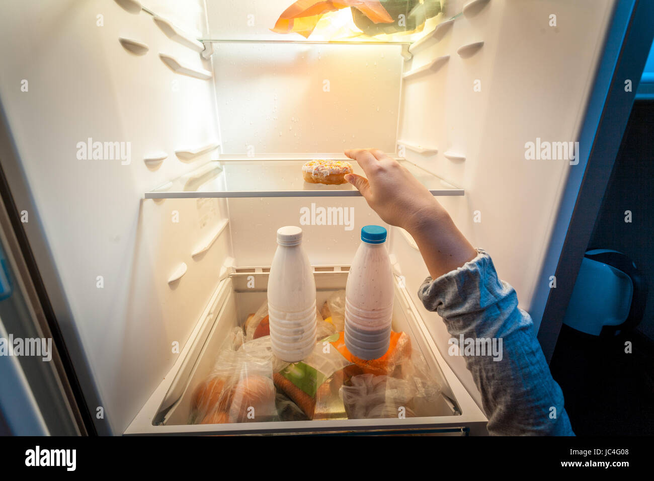 Closeup portrait of female hand taking donut from fridge Stock Photo ...