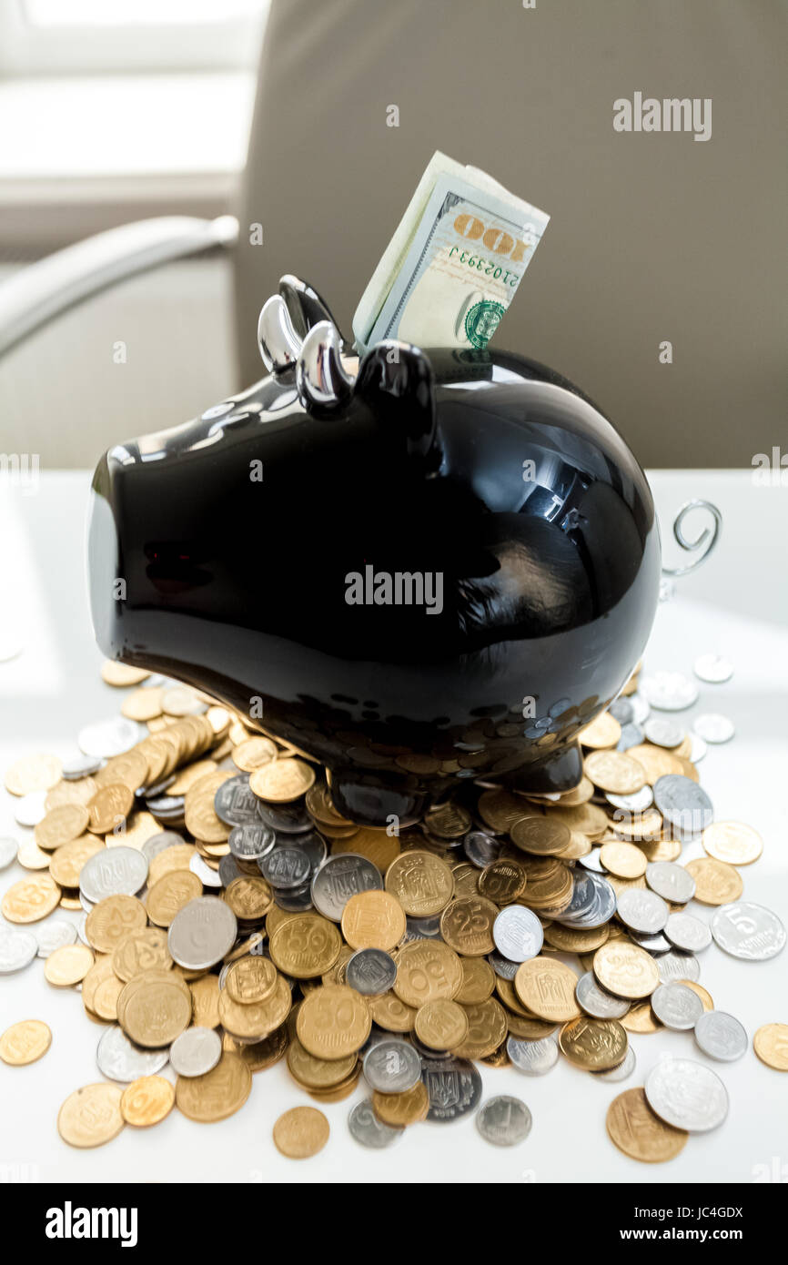 Closeup photo of piggy bank on pile of money with dollars in slot Stock ...