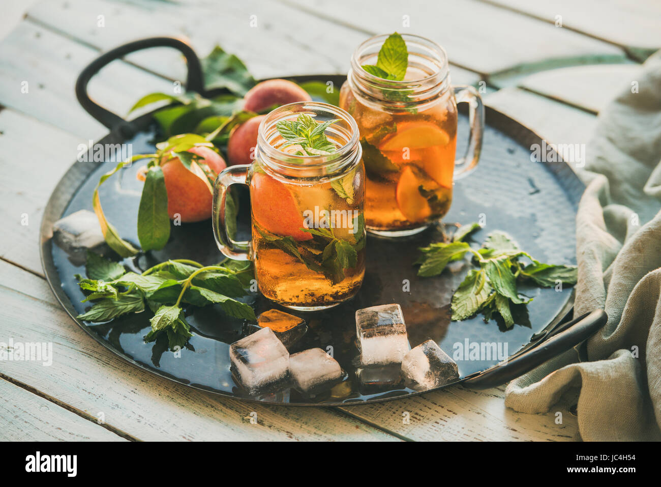 Summer refreshing cold peach ice tea on rustic wooden table Stock Photo ...