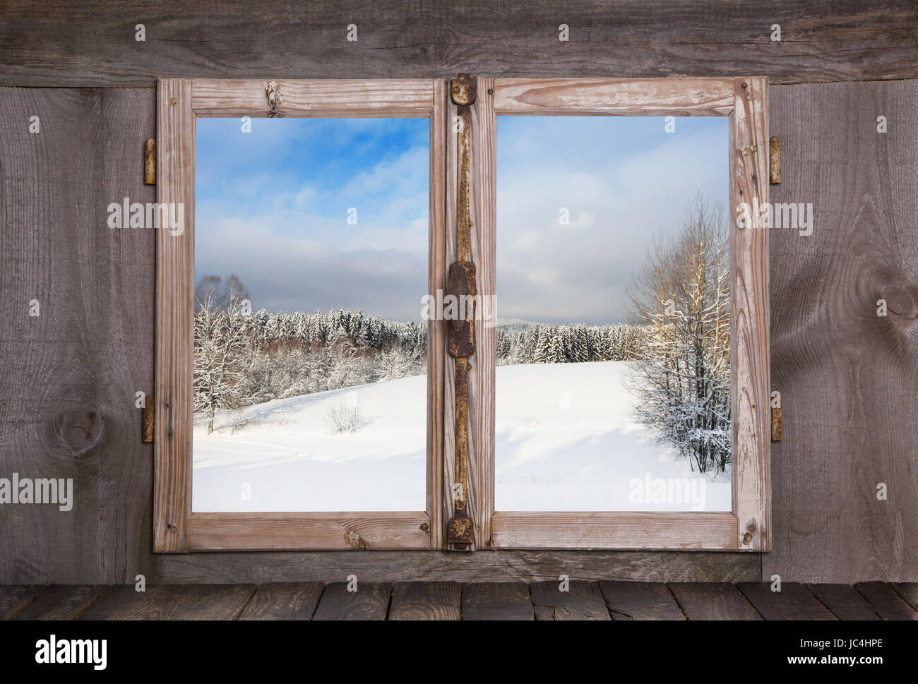 Snowy winter landscape in january. View out of an old rustic wooden ...