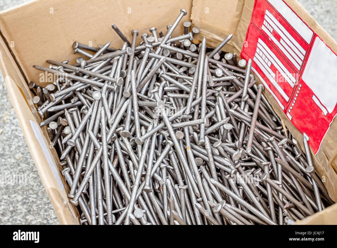 Cardboard box full with new nails, supply Stock Photo - Alamy