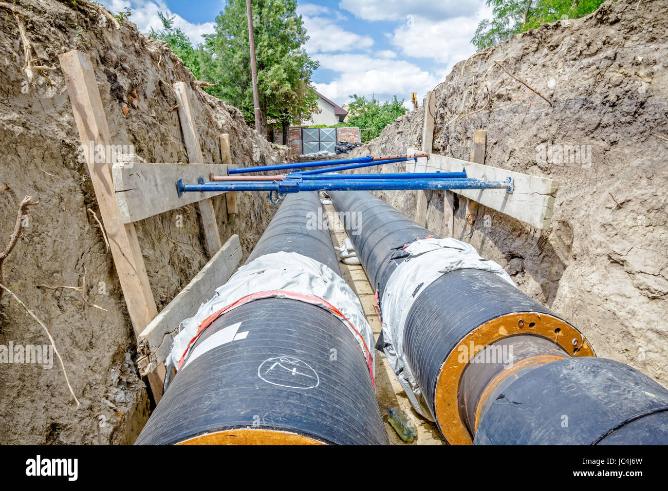 Trench walls are reinforced with supports to prevent sloughing of the ...
