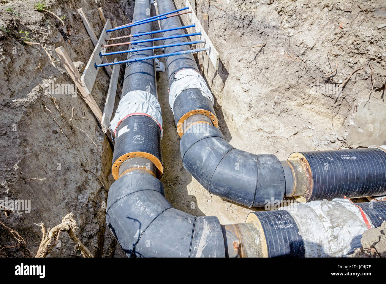 Trench walls are reinforced with supports to prevent sloughing of the ...