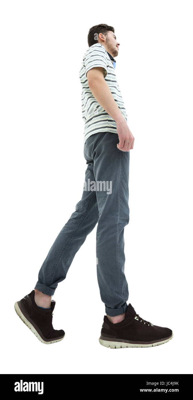 Side view of a smiling young casual man walking , On white backg Stock ...