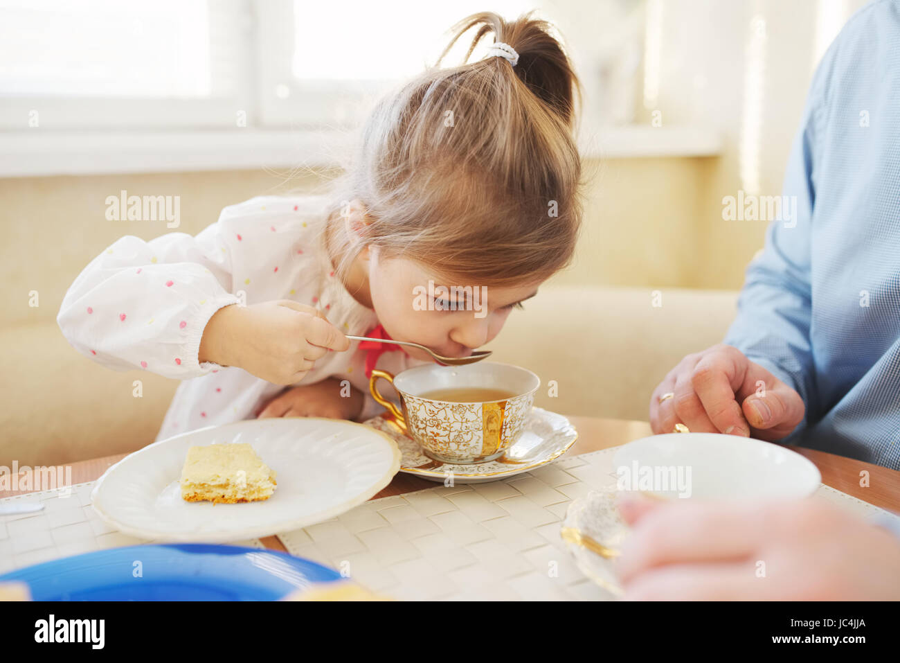 little girl drinks tea in the morning Stock Photo - Alamy