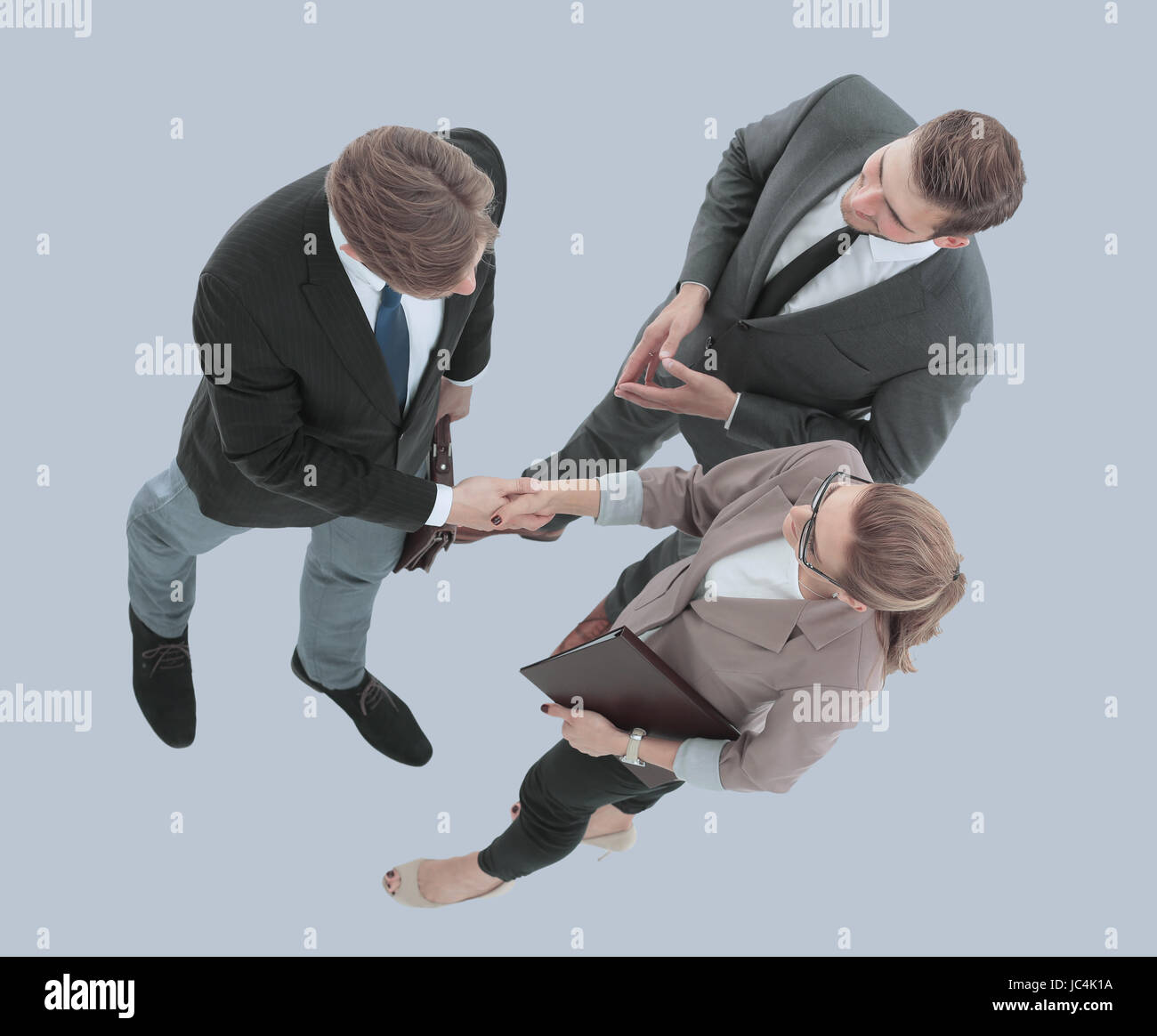 Happy business people making handshake isolated on gray Stock Photo - Alamy