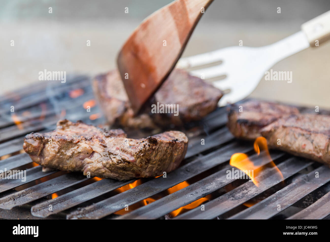 Chef grilling a beef steak on open flame BBQ Stock Photo - Alamy