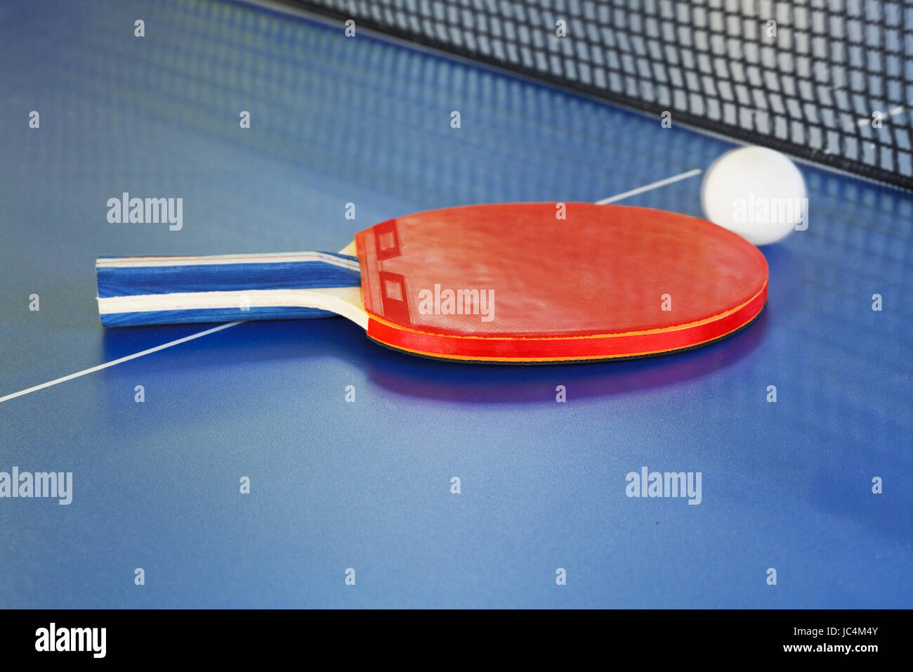 red paddle, tennis ball on blue ping pong table close up Stock Photo ...