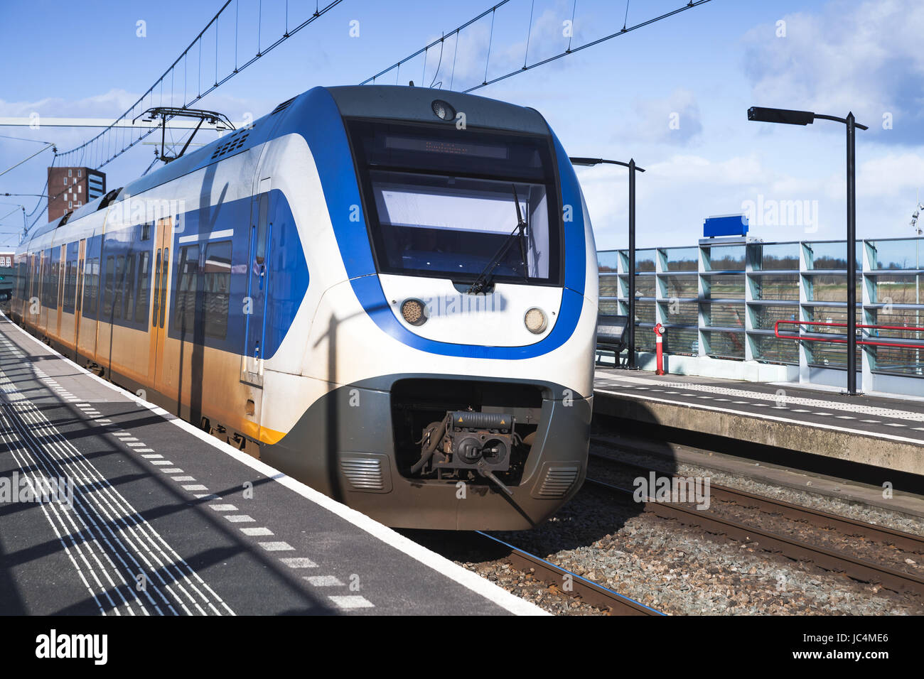 Passenger electric train goes near railway station in Amsterdam ...