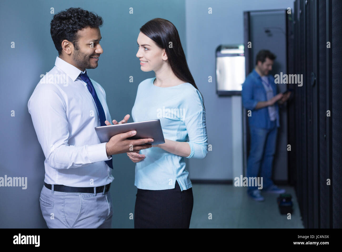 Nice positive colleagues looking at each other Stock Photo - Alamy