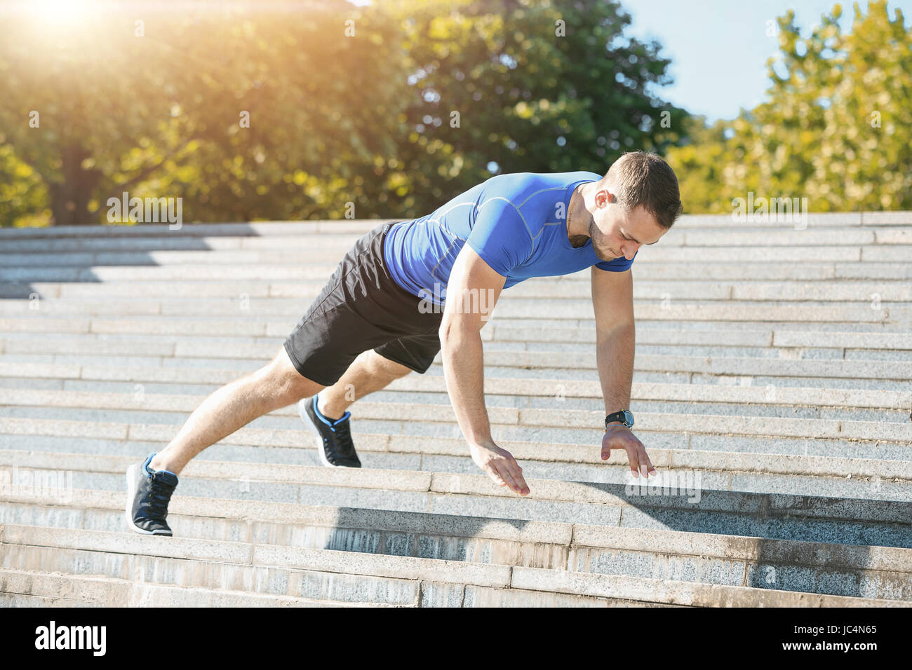 Fit man doing exercises outdoors at park Stock Photo - Alamy
