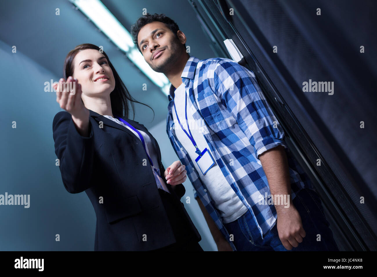 Joyful helpful woman standing with her colleague Stock Photo - Alamy