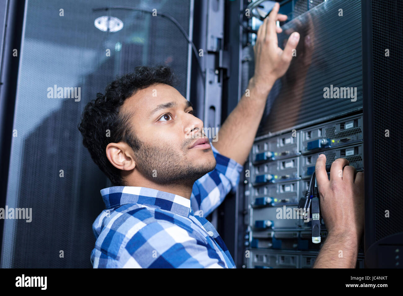 Handsome pleasant technician holding cables Stock Photo - Alamy
