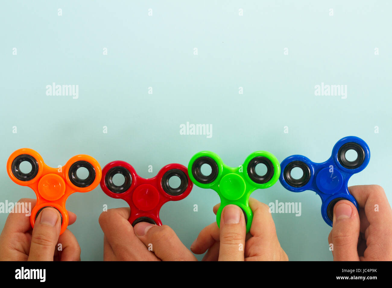 trendy fidget spinners - styled flat lay scene with hands holding ...
